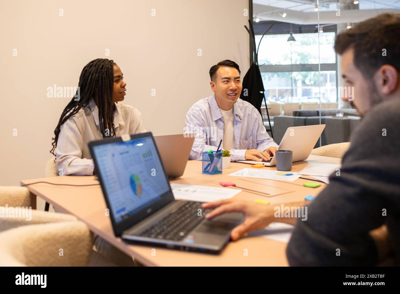 A multicultural group of friends or colleagues engage in a team meeting ...
