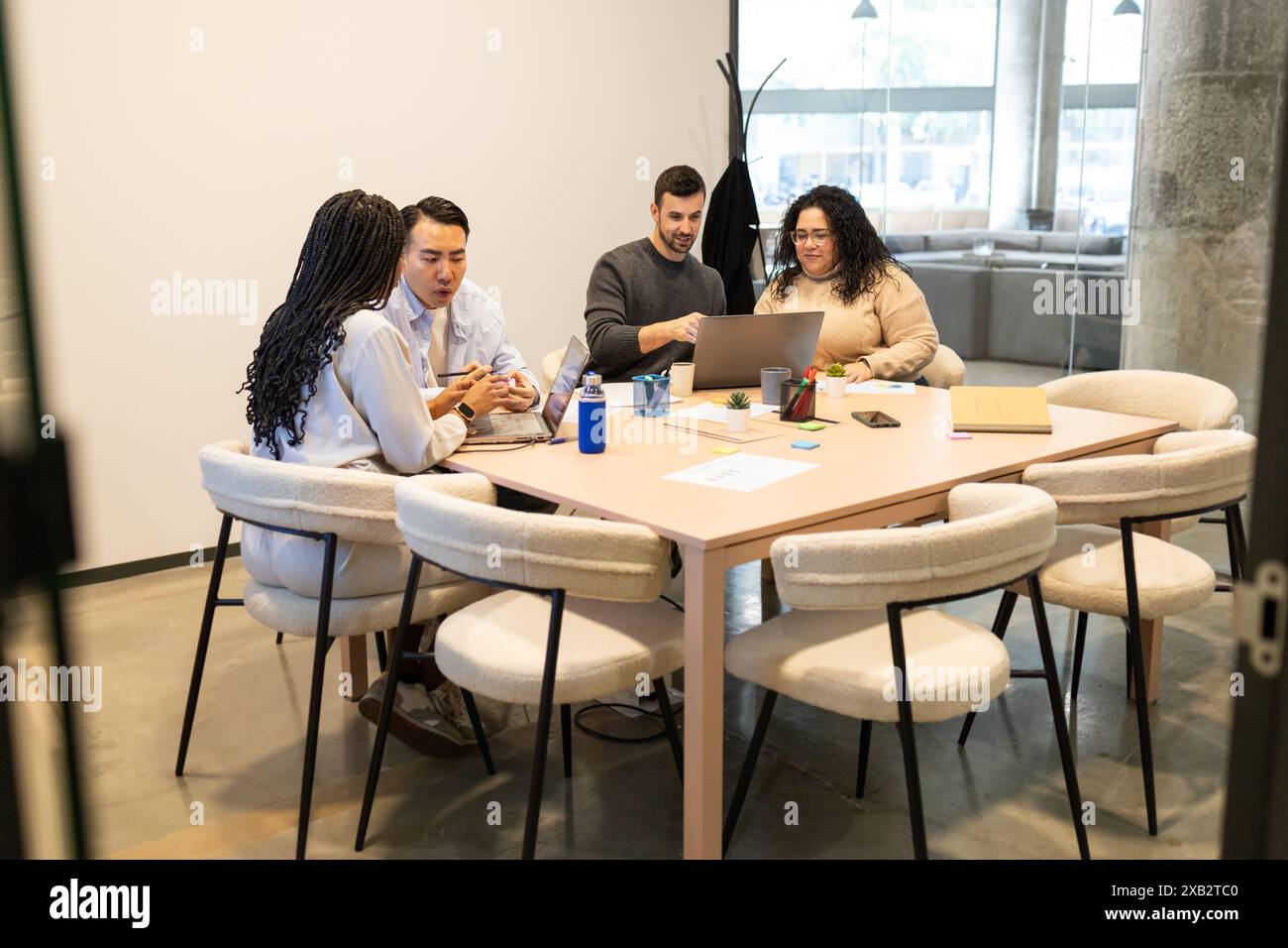 A diverse group of friends engaged in a collaborative work session at a ...