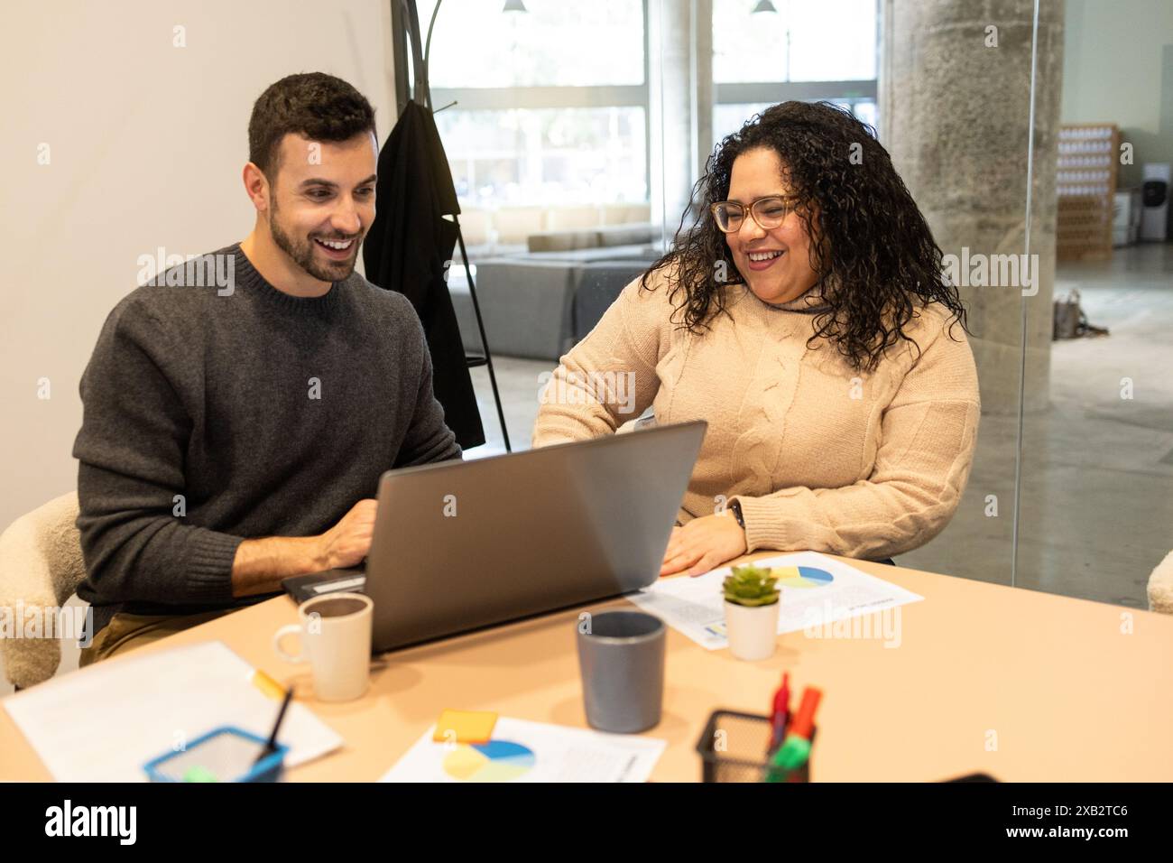 Two friends share a joyful moment while working on a project in a well ...