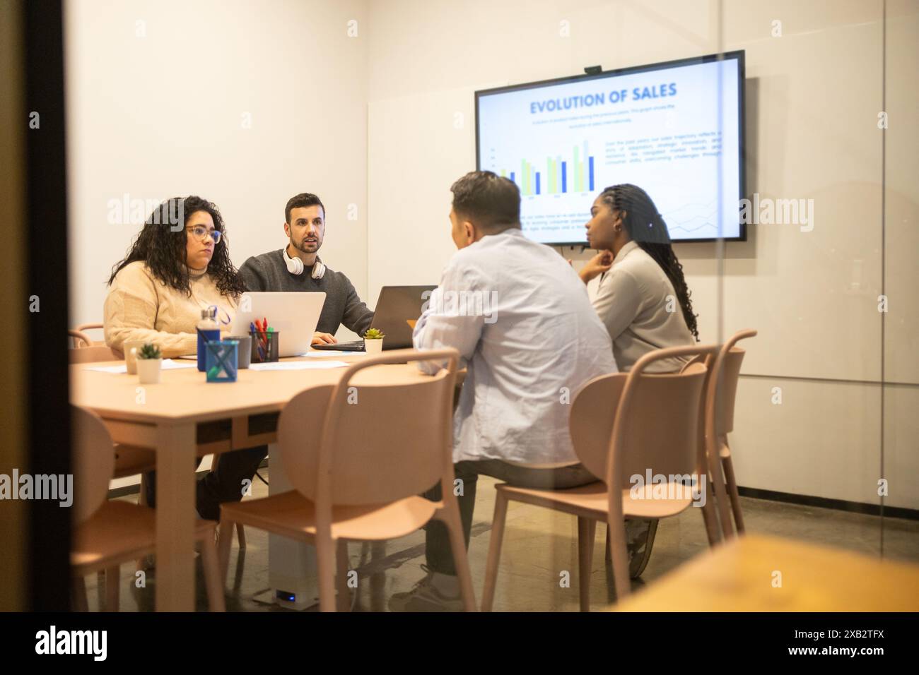 A group of colleagues attentively participates in a team meeting ...