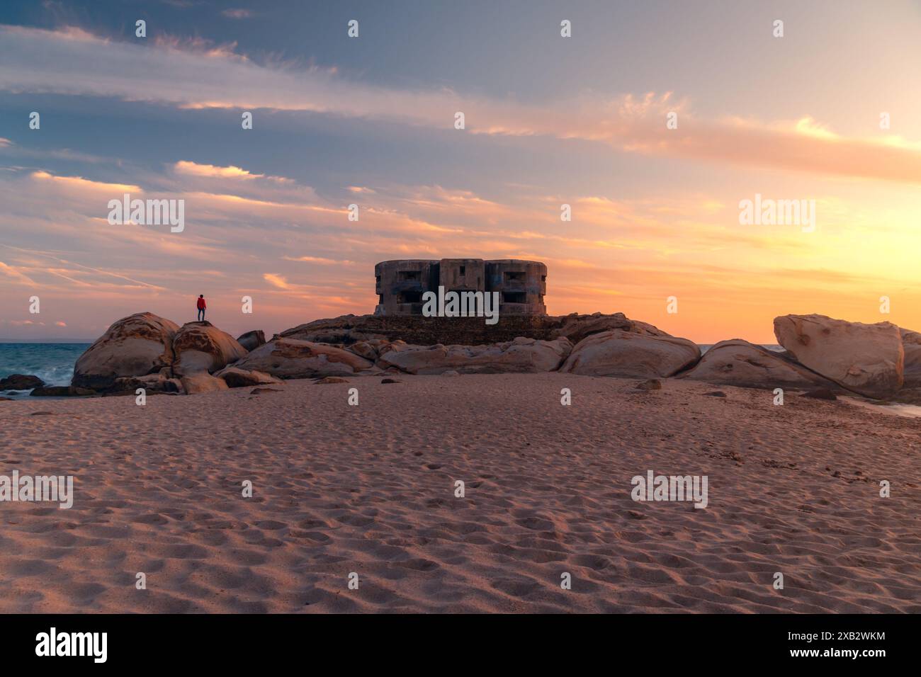 Back view of unrecognizable person stands atop a smooth boulder against ...