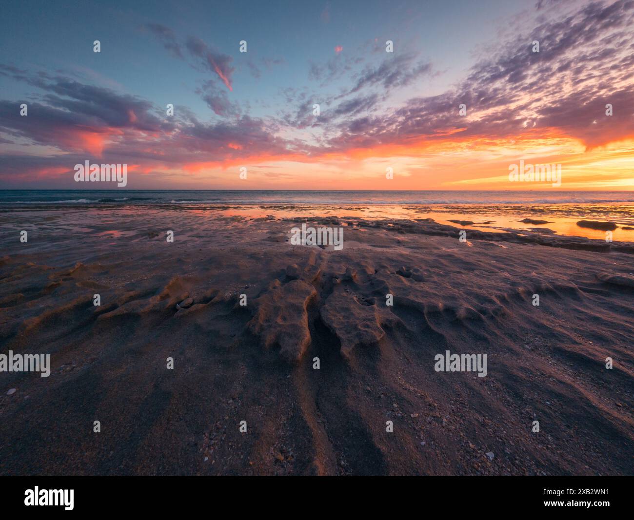 Vibrant sunset paints the skies above the Atlanterra Beach ...