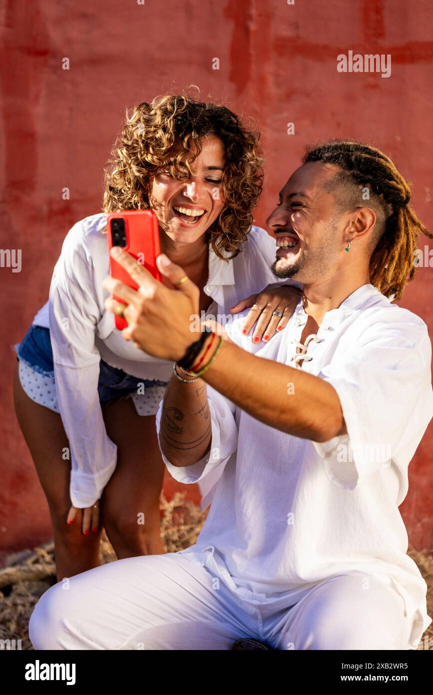 Joyful Couple Enjoys A Warm Sunny Day Capturing Selfies With A Red