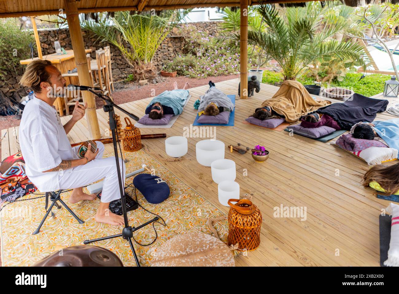 Side view of a male leading in serene outdoor sound therapy session ...