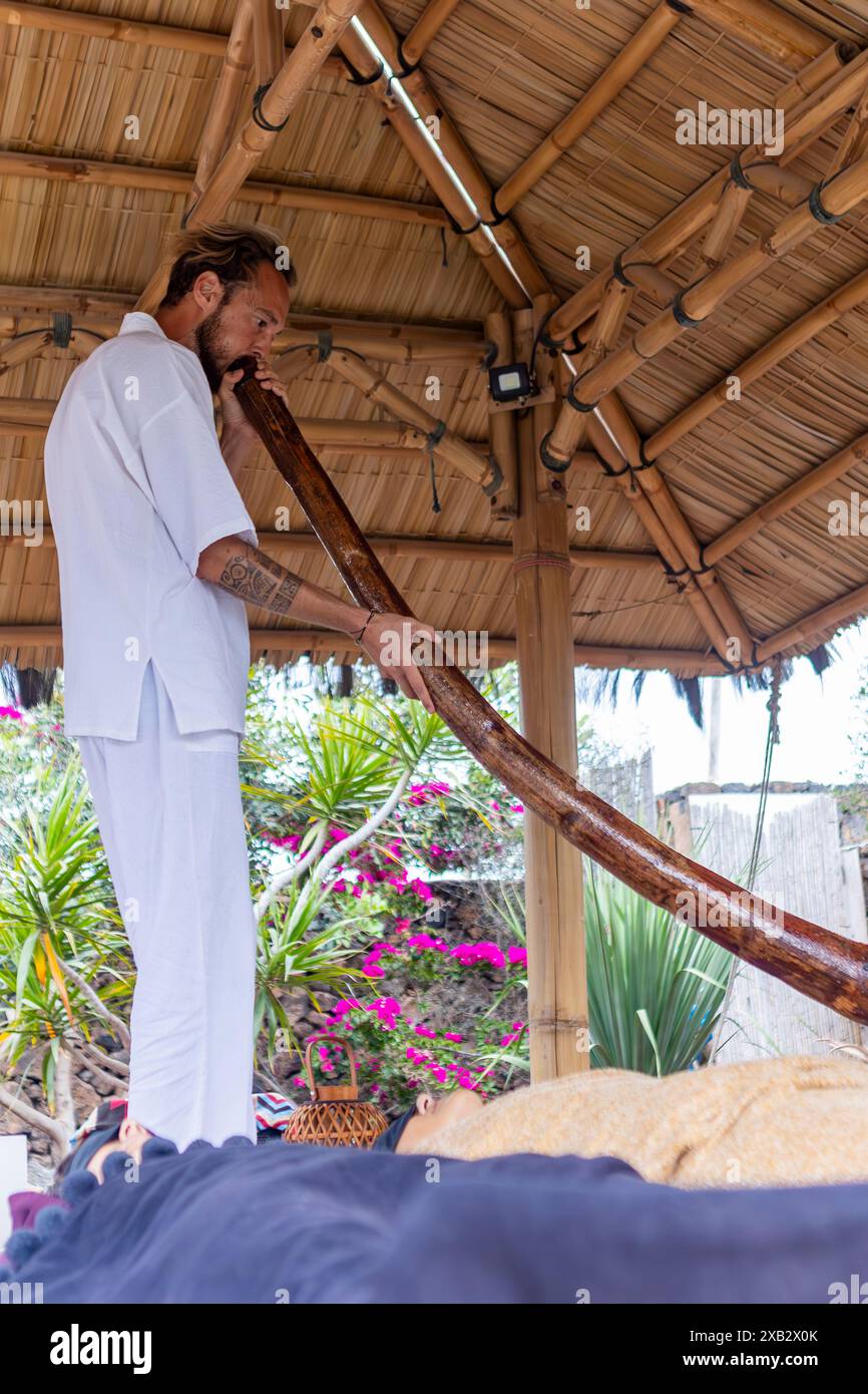 Man playing a didgeridoo during a sound therapy session with ...