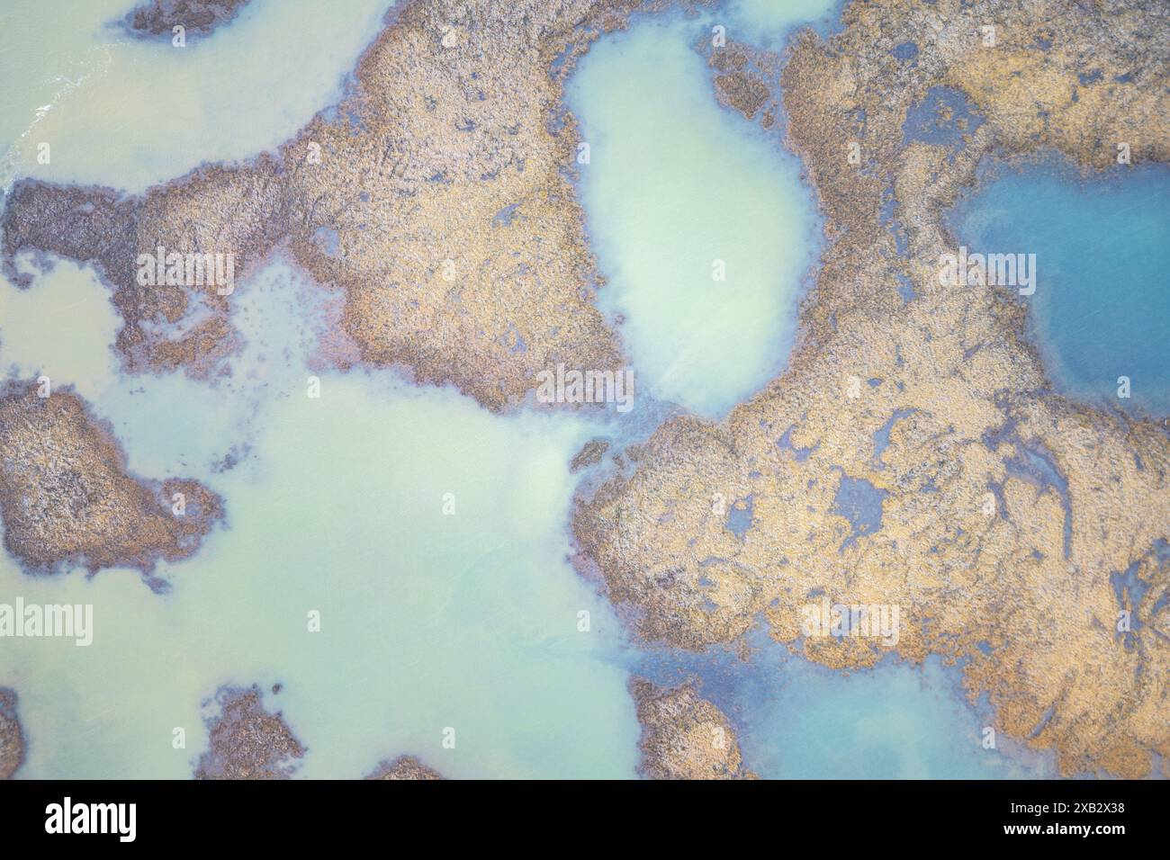 A drone capture of turquoise geothermal pools surrounded by silt on ...