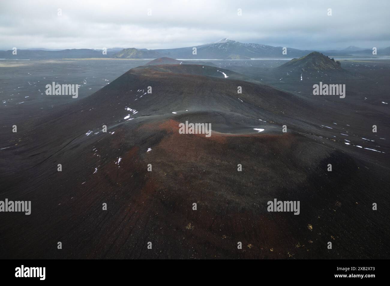 Aerial view of a serene volcanic cone amidst the rugged terrain of the ...