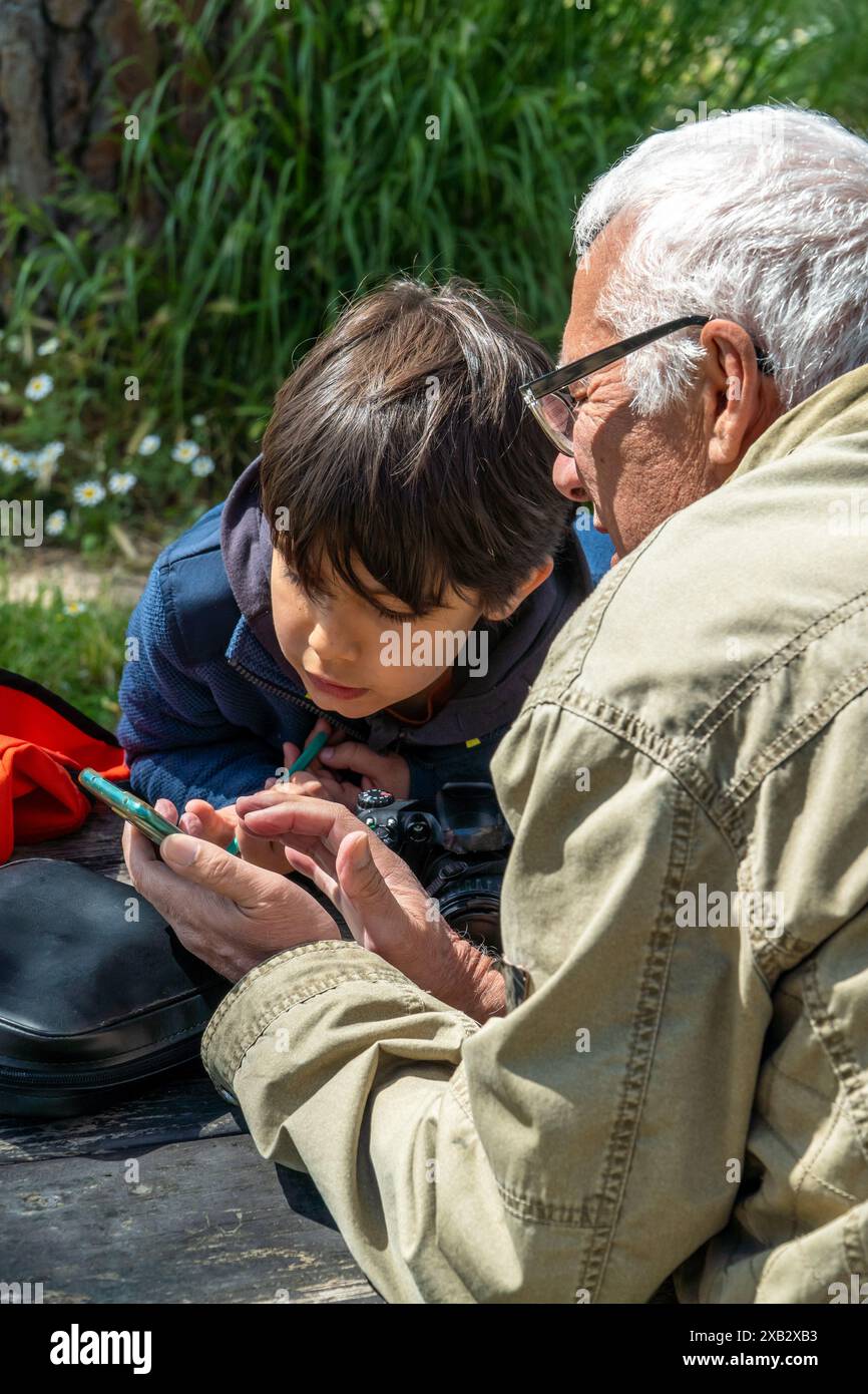 Grandfather and young boy enjoy a lesson in nature on a sunny spring ...