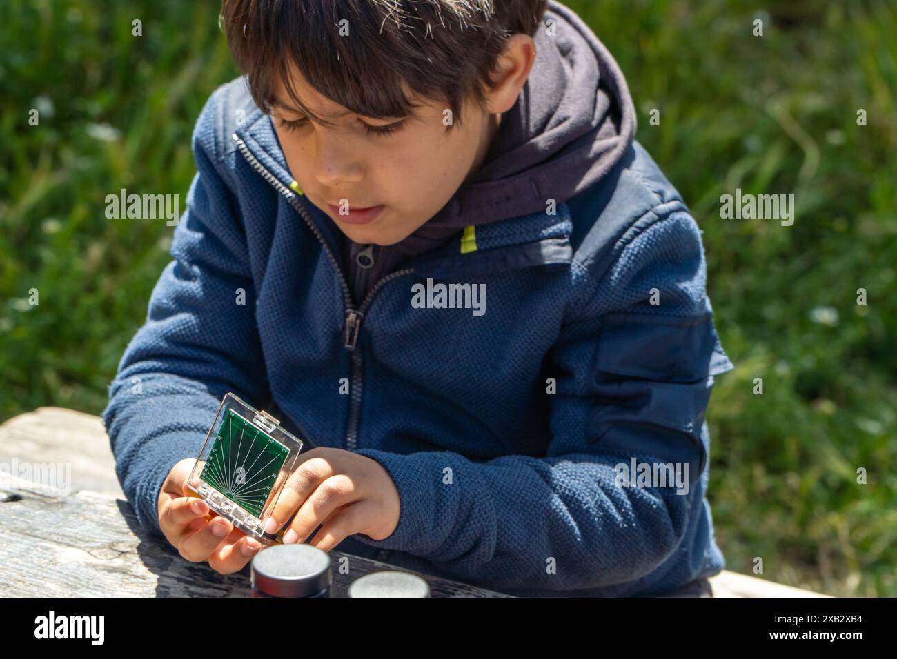 A focused young boy engages with a solar panel energy experiment on a ...