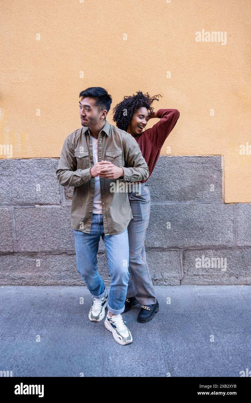 A cheerful multiethnic couple, composed of a Chinese man and a Hispanic ...