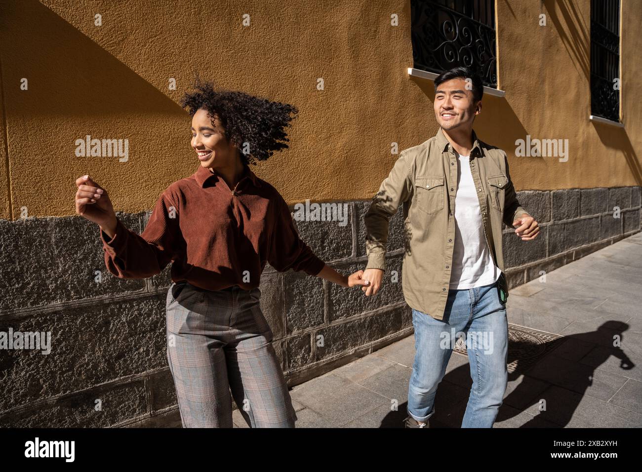 A cheerful multiethnic couple, composed of a Chinese man and a Hispanic ...