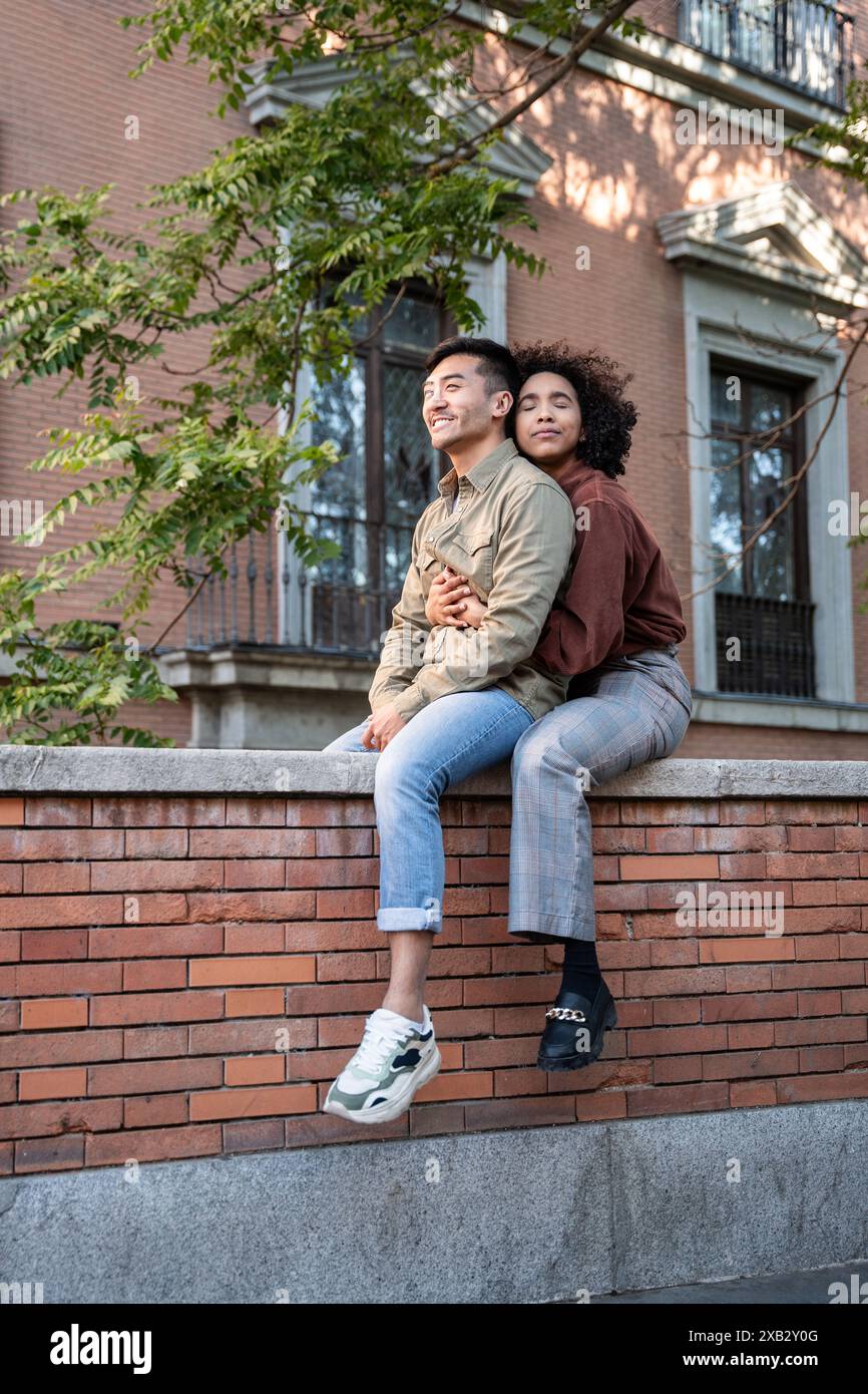 A multiethnic couple, a Chinese man and a Hispanic woman, embraces ...
