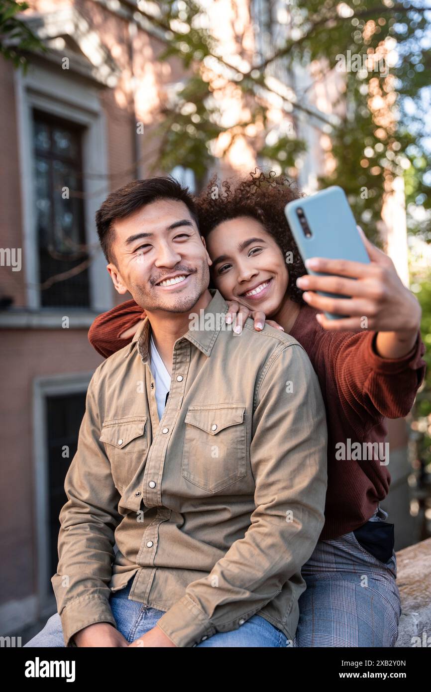A multiethnic couple, composed of a smiling Chinese man and a Hispanic ...