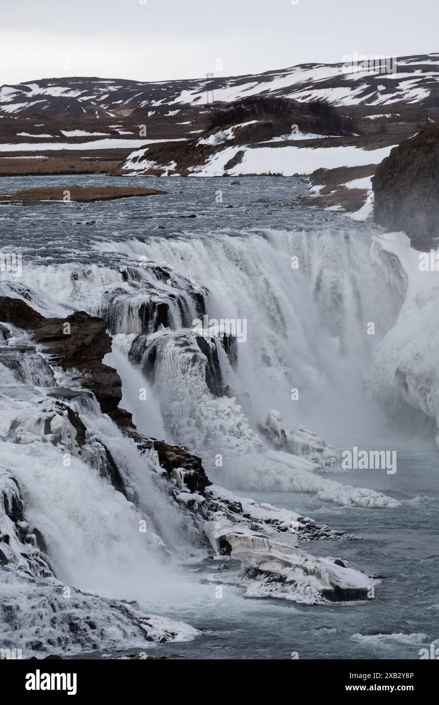 A spectacular view of a frozen waterfall cascading amidst the snowy and ...