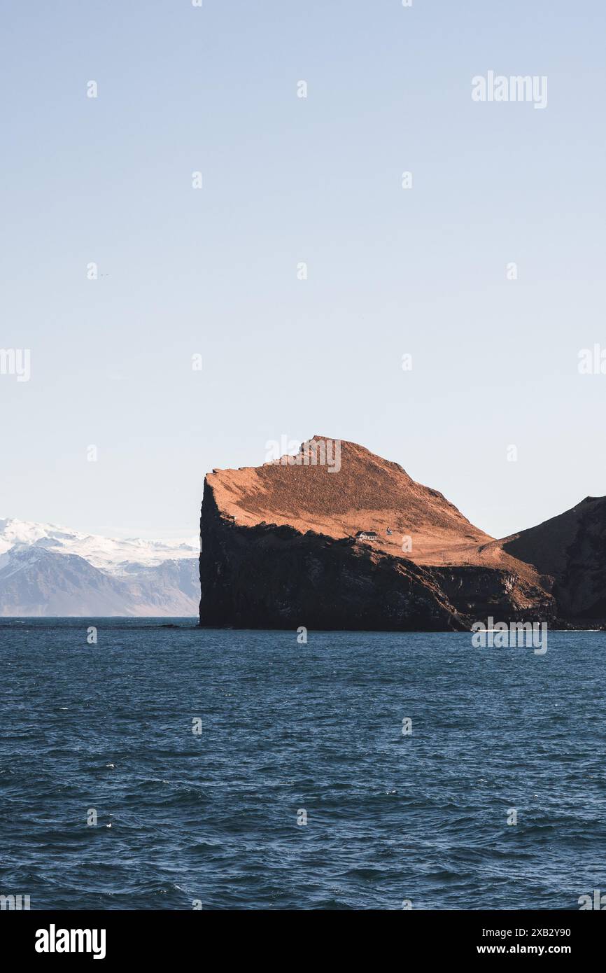 Majestic rock formation rising from the ocean at Westman Islands, with ...