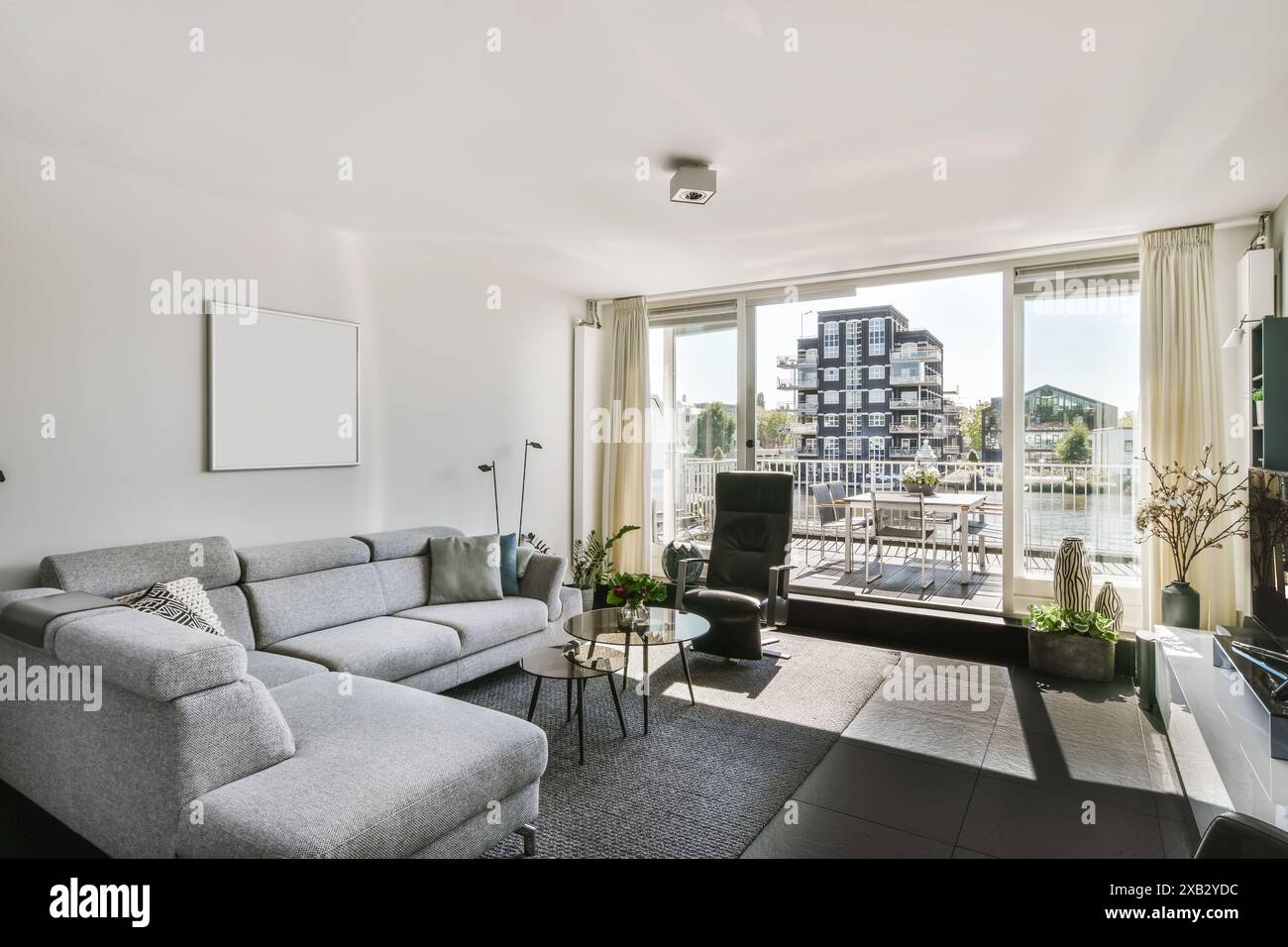 This contemporary living space features a stylish grey sectional sofa ...