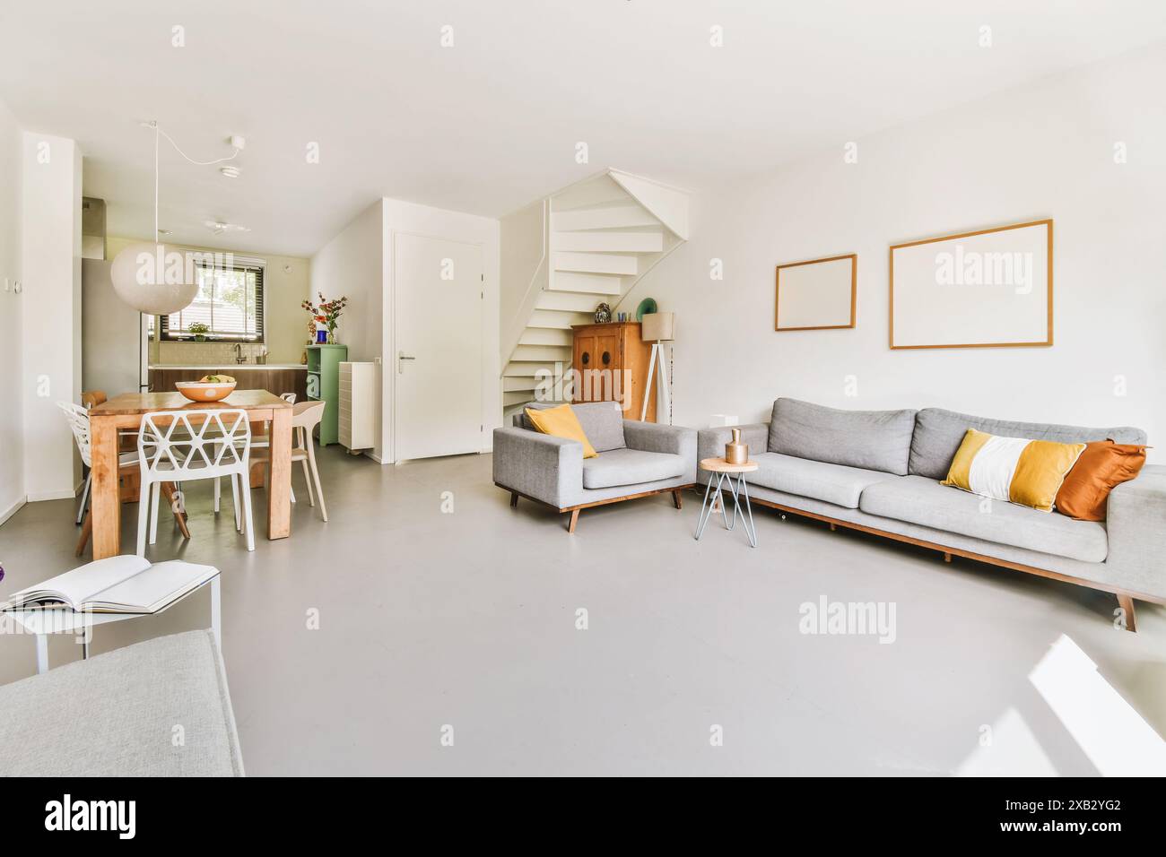 A spacious open-plan living area with modern furniture, white walls ...