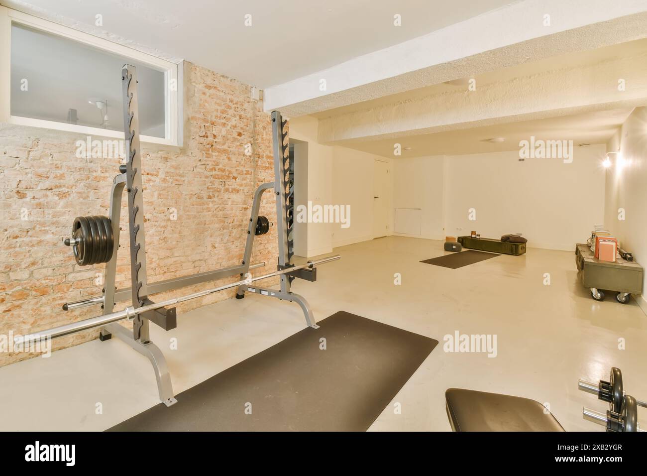 Spacious home gym with industrial chic exposed brick wall, modern ...