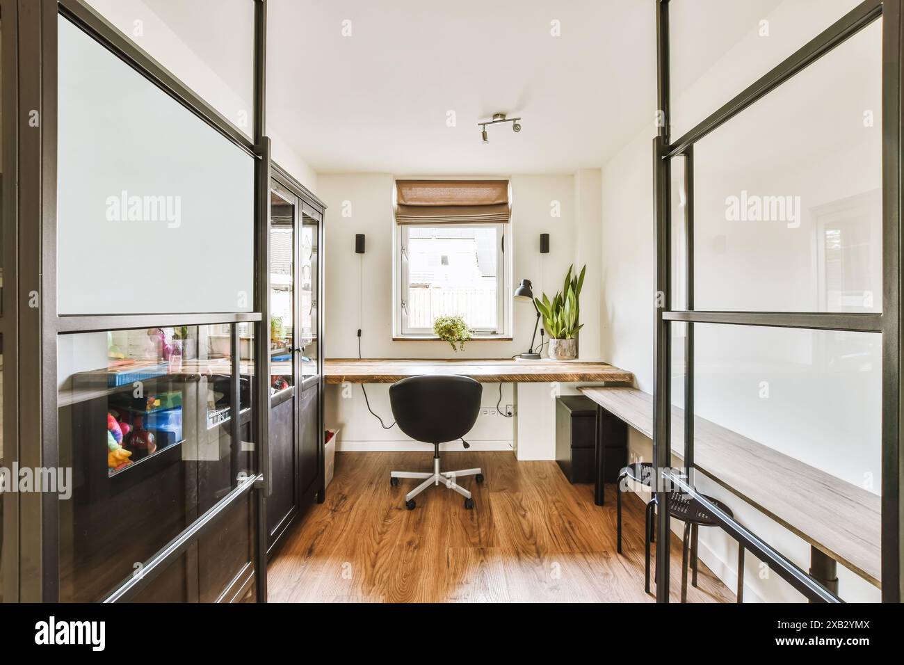 This well-lit home office, featuring sleek glass partitions and classic ...