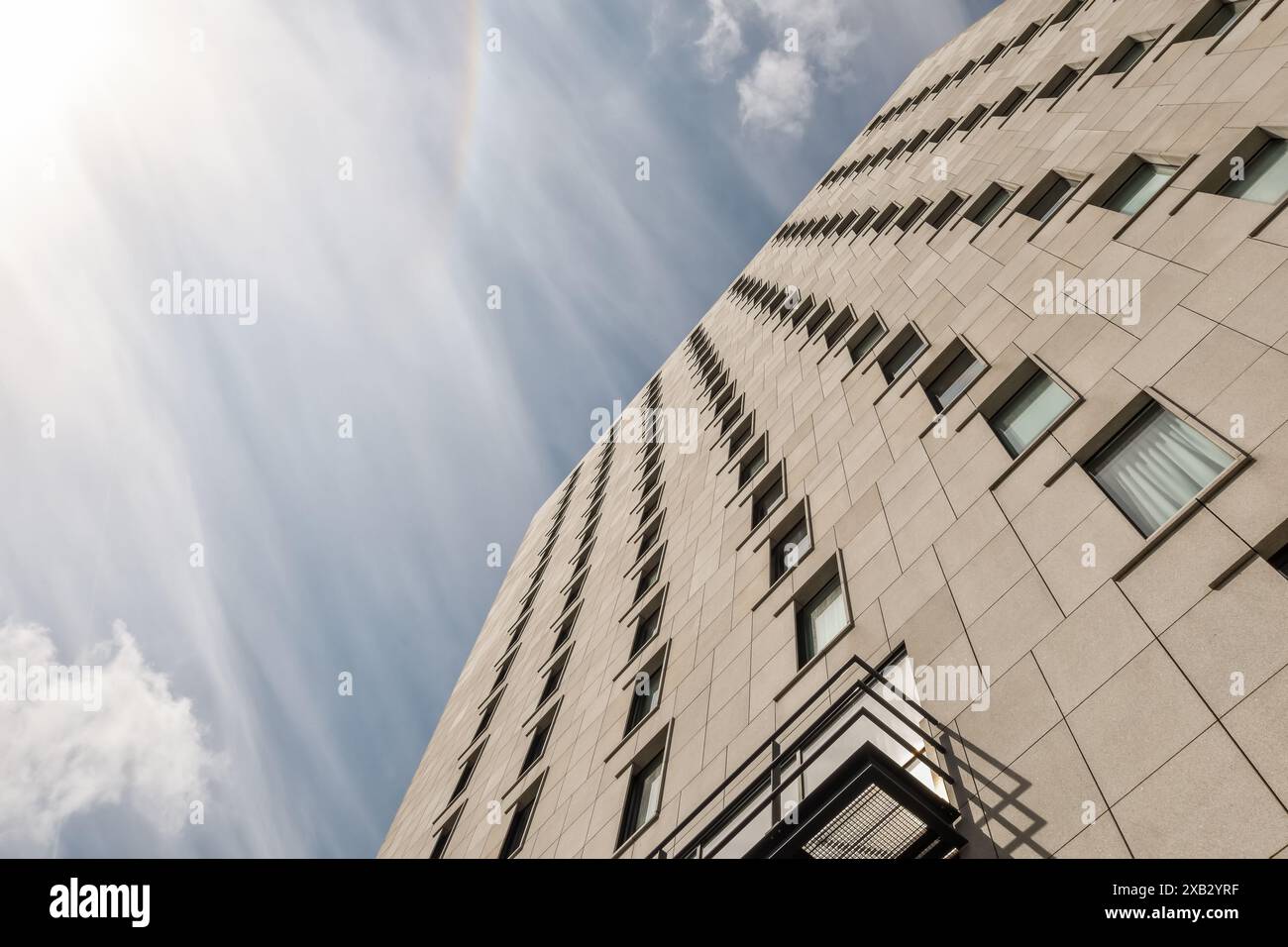 Upward view of a modern high-rise building with numerous windows and a ...