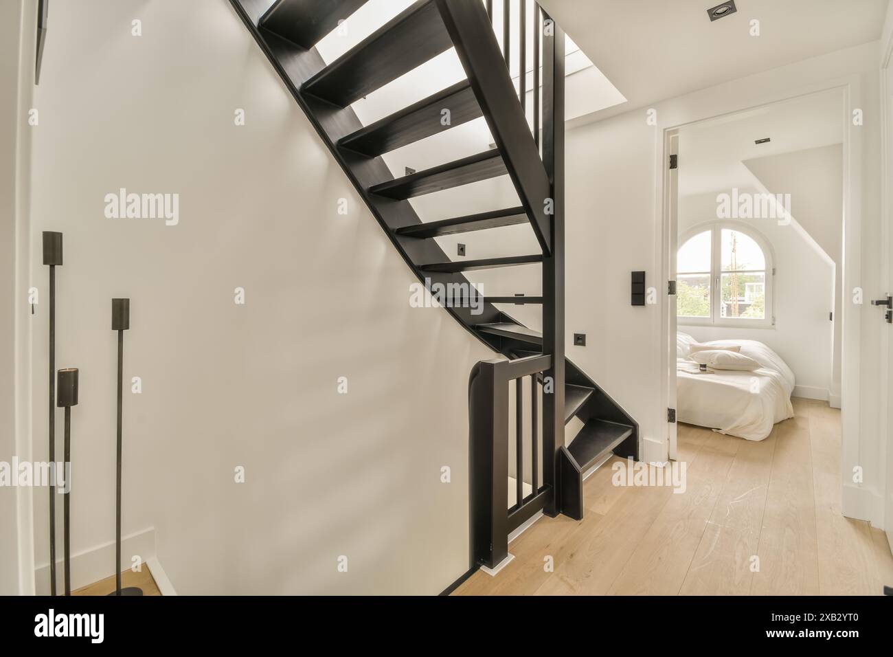 A contemporary home interior featuring a black modern staircase with a ...