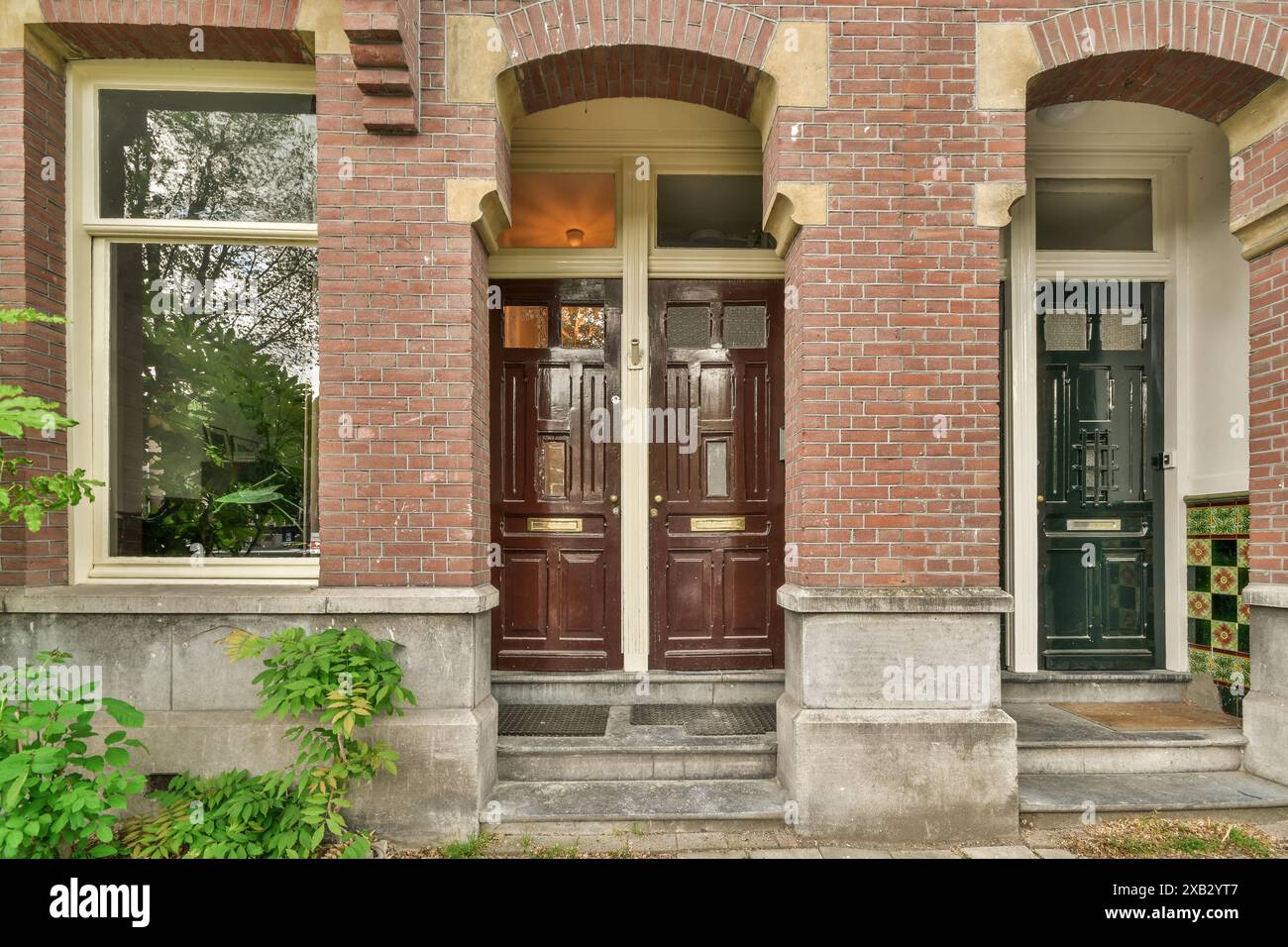 Classic red brick house facade with ornate wooden doors and white ...