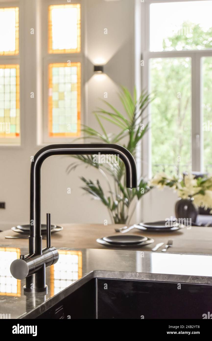 A close-up view of a modern kitchen's black faucet and sink with a ...