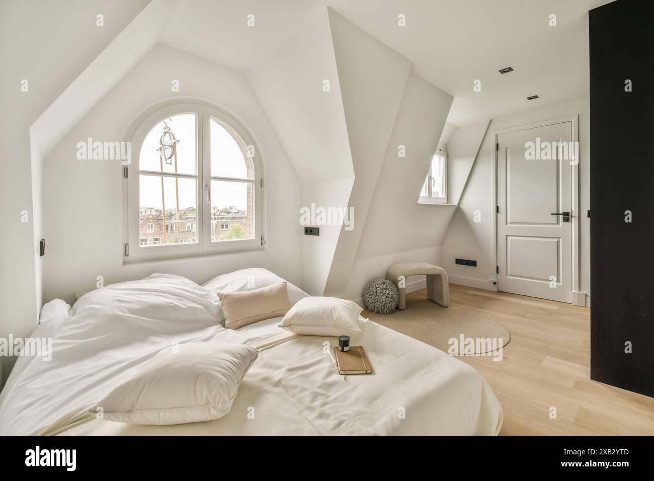 An airy, minimalist attic bedroom featuring geometric angles, a large ...