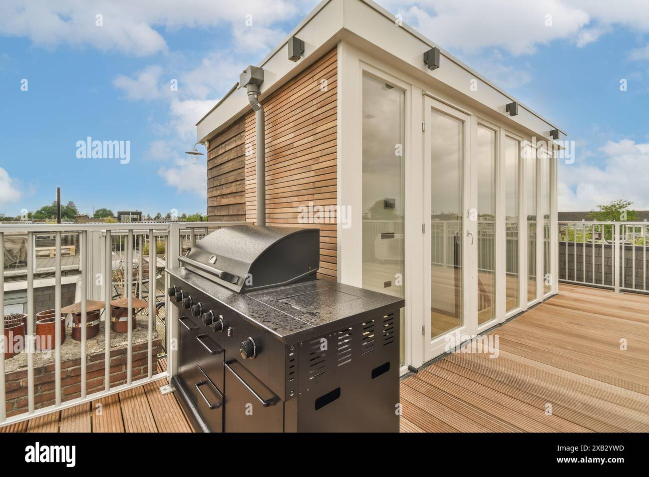 This stylish rooftop terrace features a sleek outdoor kitchen grill ...