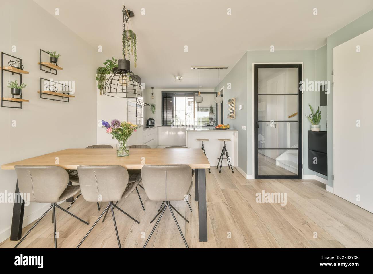 A contemporary kitchen combined with a dining area featuring a large ...