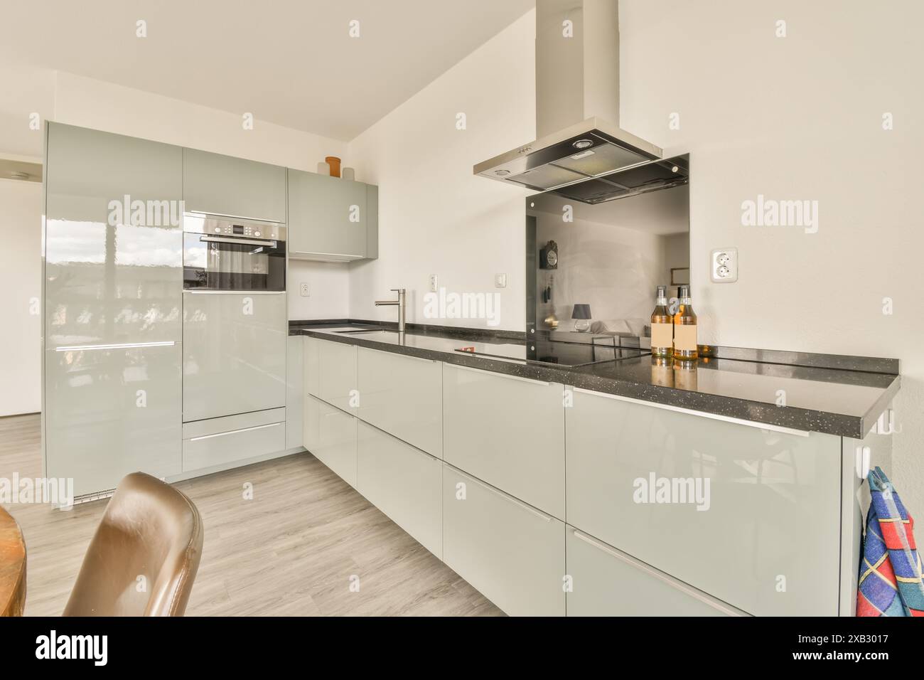 A contemporary kitchen featuring glossy cabinets, integrated appliances ...