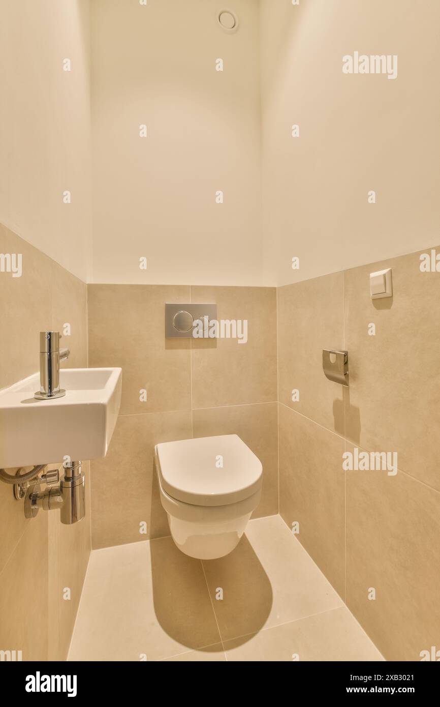 A compact and stylish modern bathroom with neutral-colored tiles, white ...