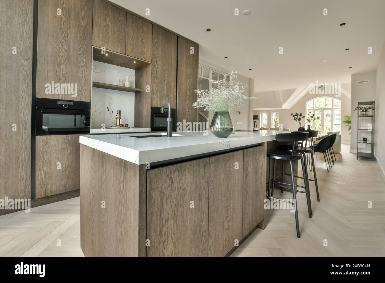 An elegantly designed modern kitchen featuring wooden cabinet finishes ...