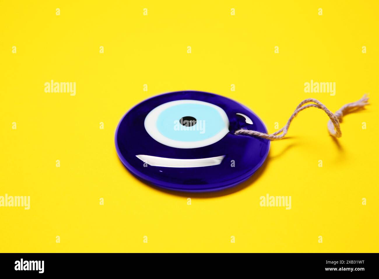Traditional evil eye amulet on yellow background Stock Photo - Alamy
