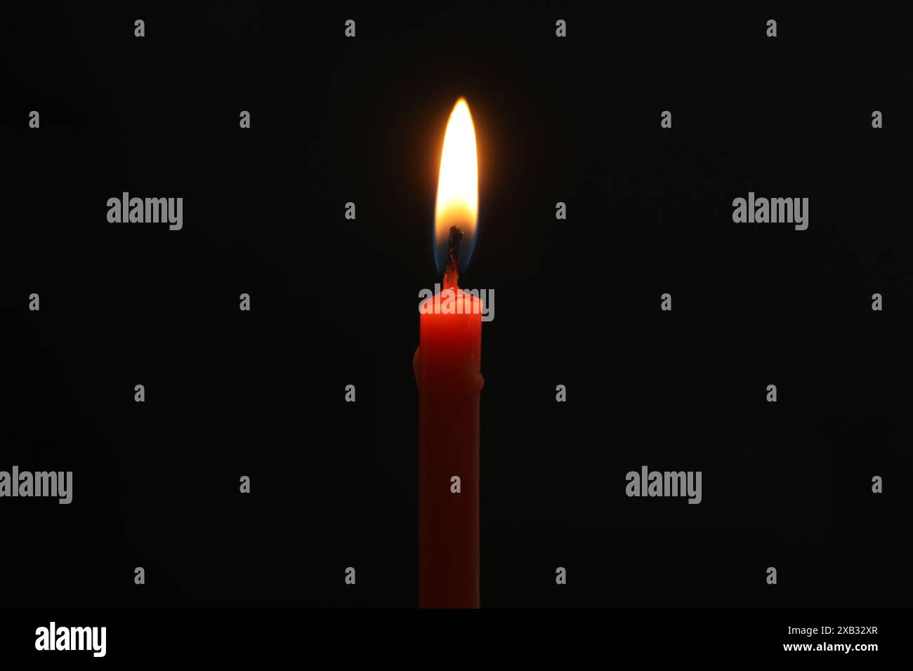 One burning church candle on black background Stock Photo - Alamy