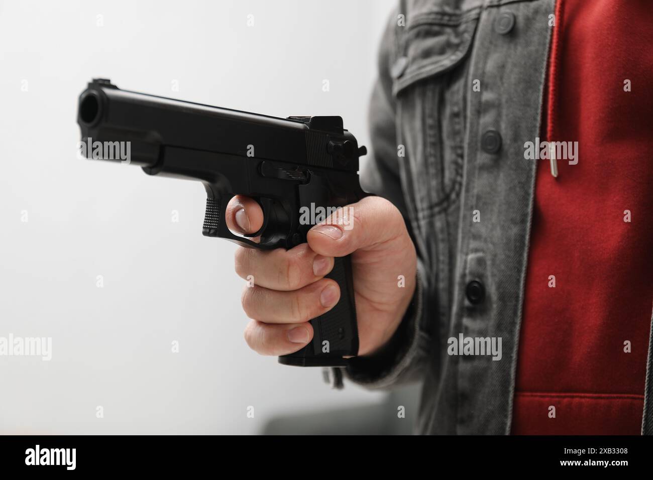Dangerous criminal with gun indoors, closeup. Armed robbery Stock Photo ...