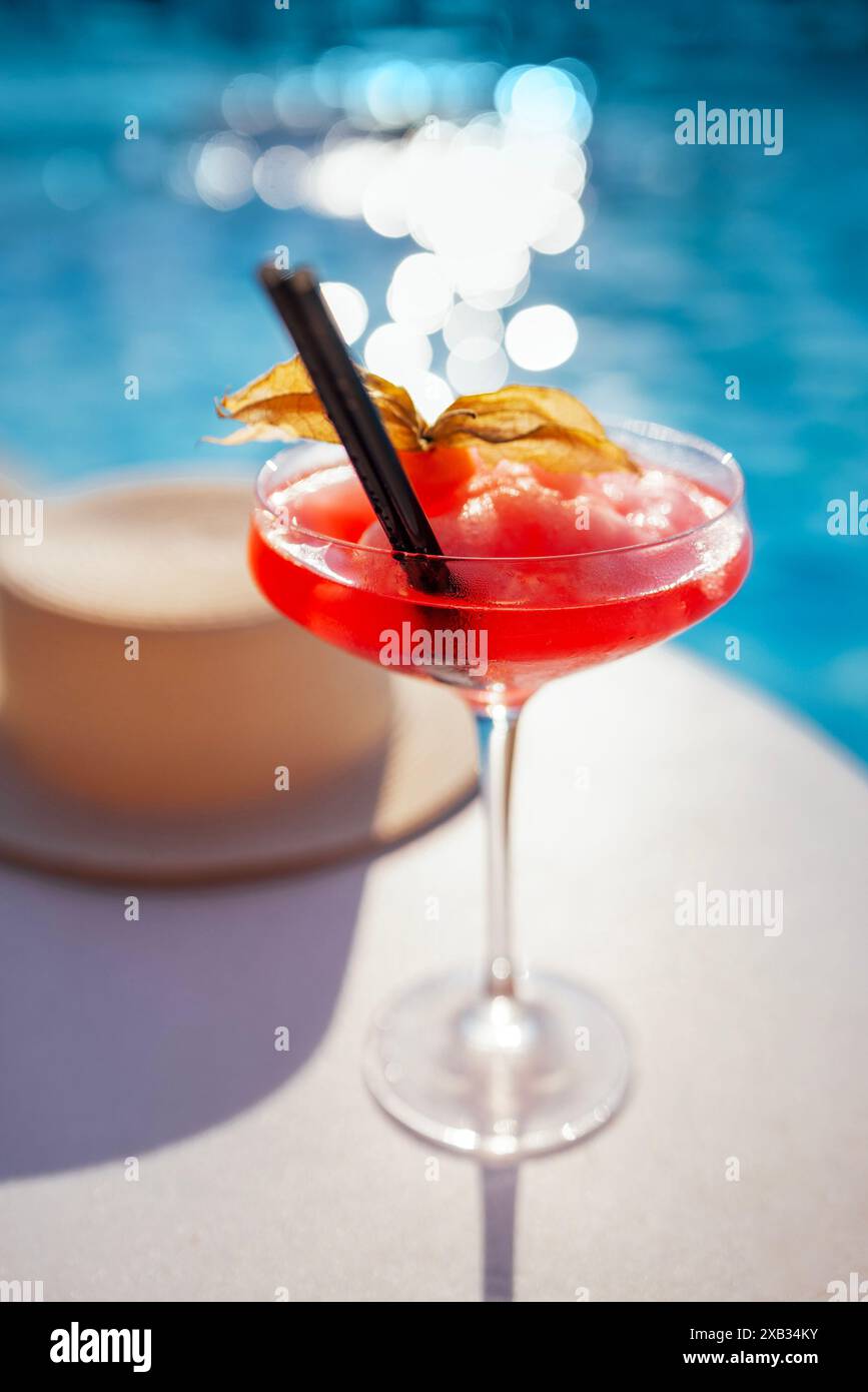 A red drink in an elegant glass with a long stem on the side of the ...