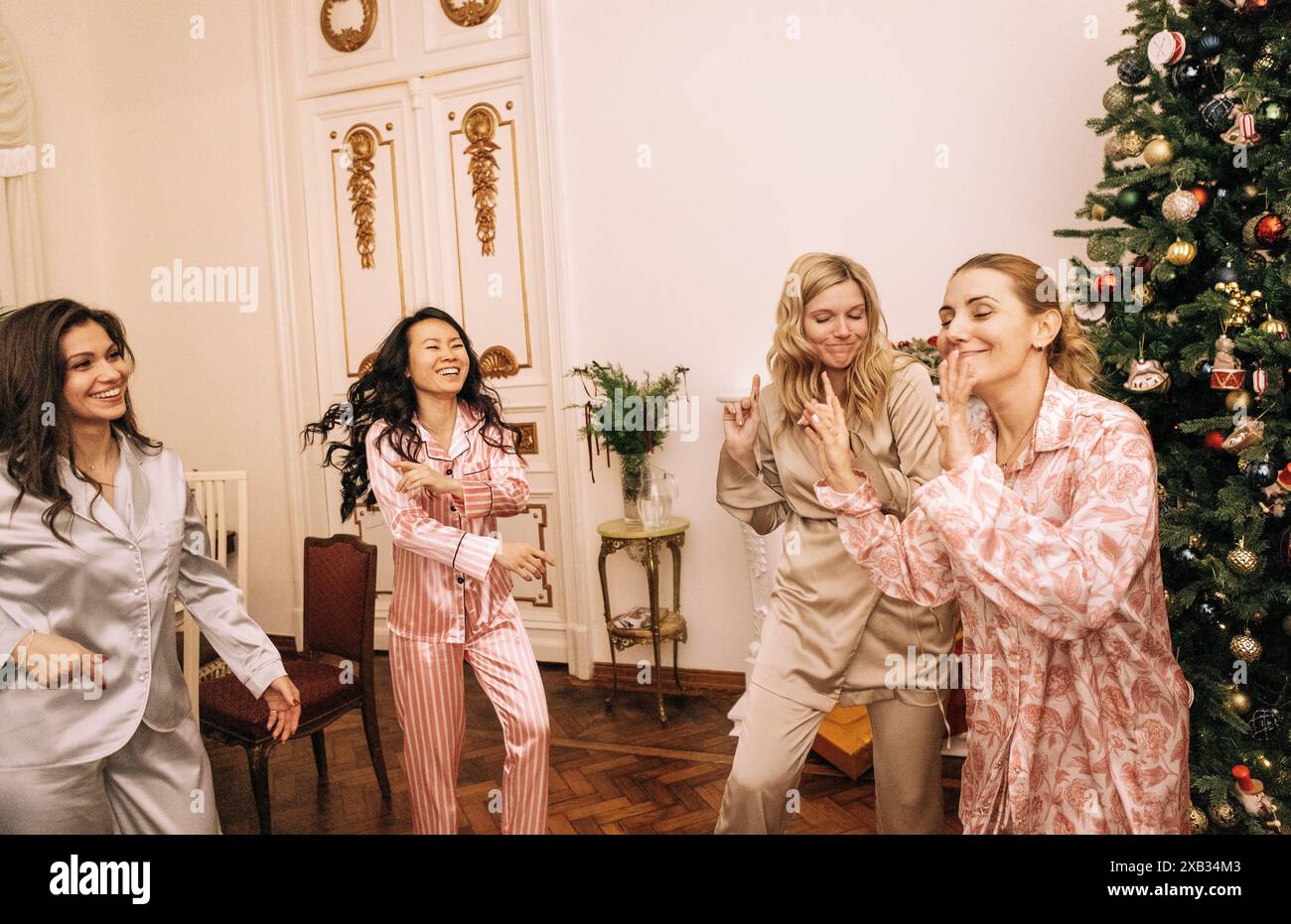 Young women of different nationalities in pajamas dancing near ...