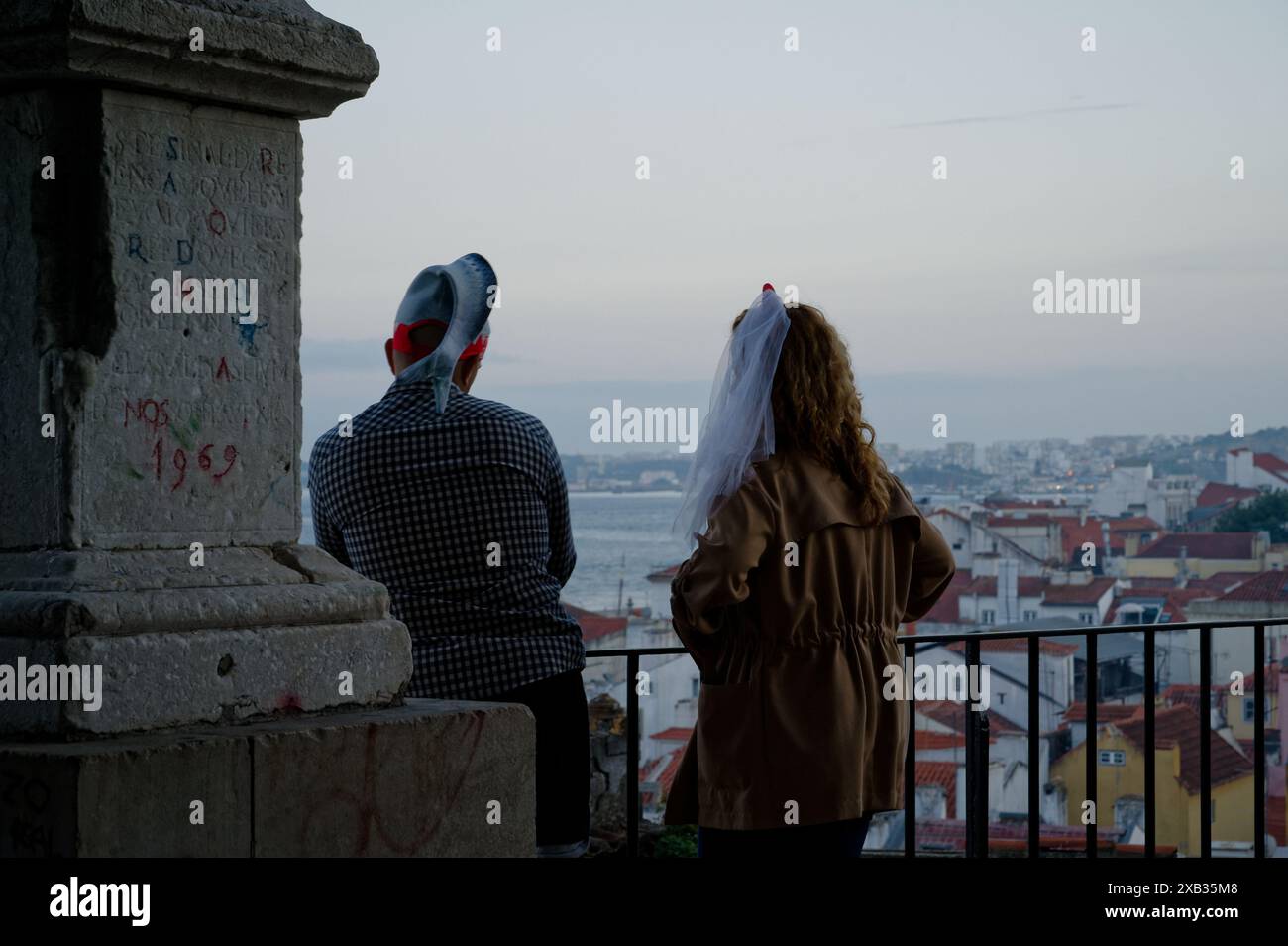 Man wearing a sardine hat and a woman with a veil take in the view ...
