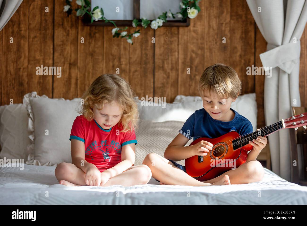 Cute sweet toddler children, tickling feet on the bed, laughing and ...