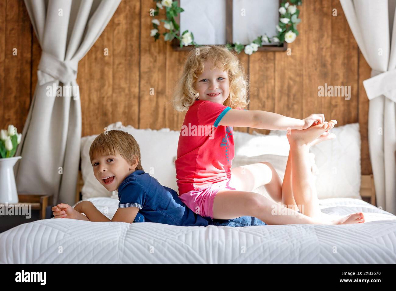 Cute sweet toddler children, tickling feet on the bed, laughing and ...
