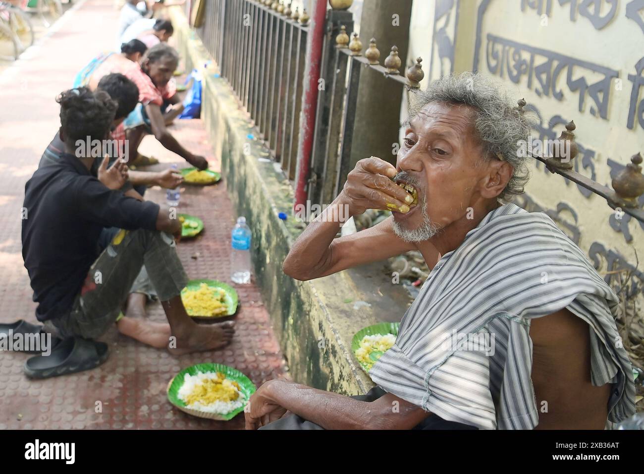 People eating food distributed by a social worker on World Food Safety ...