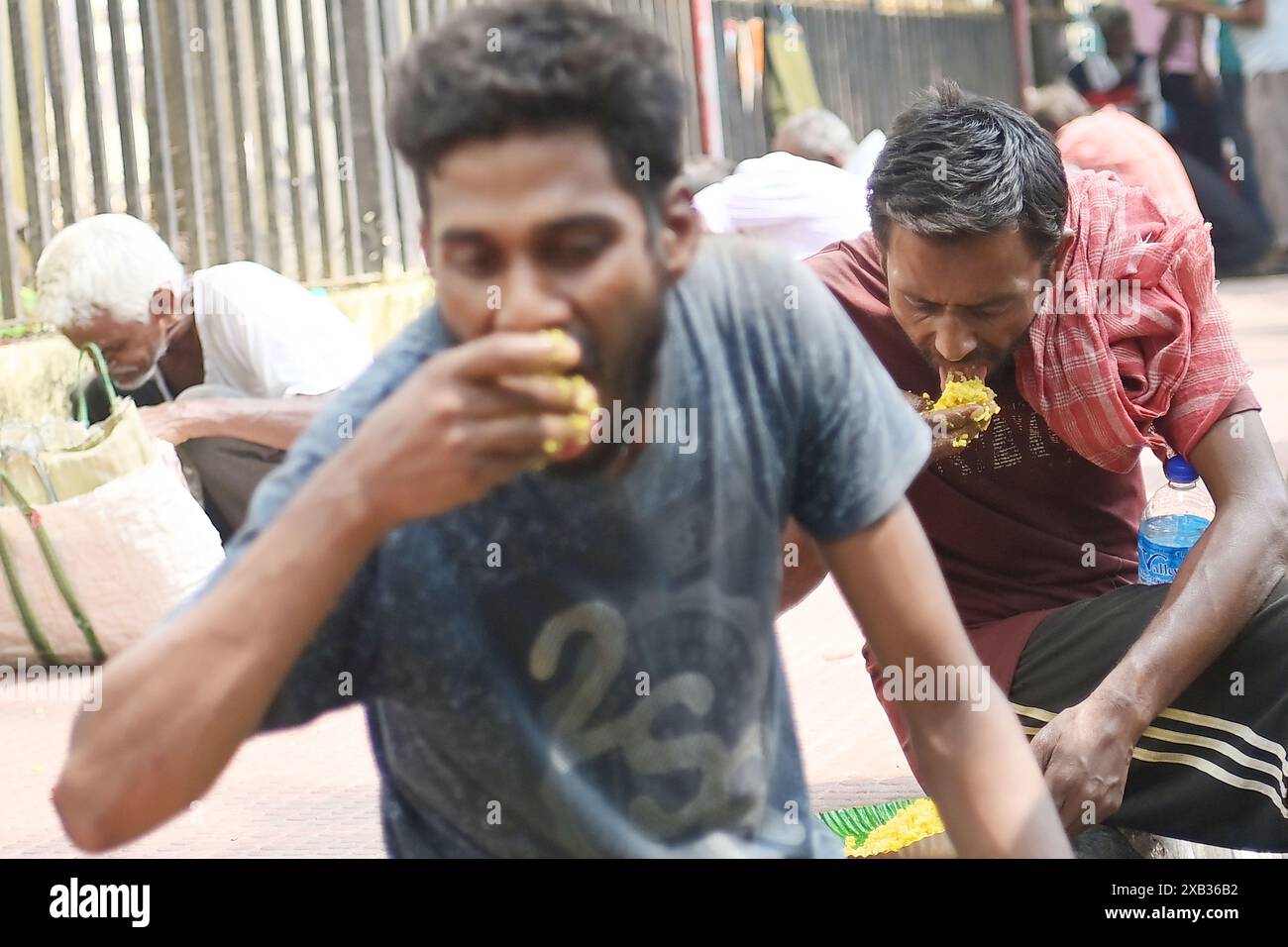 People eating food distributed by a social worker on World Food Safety ...