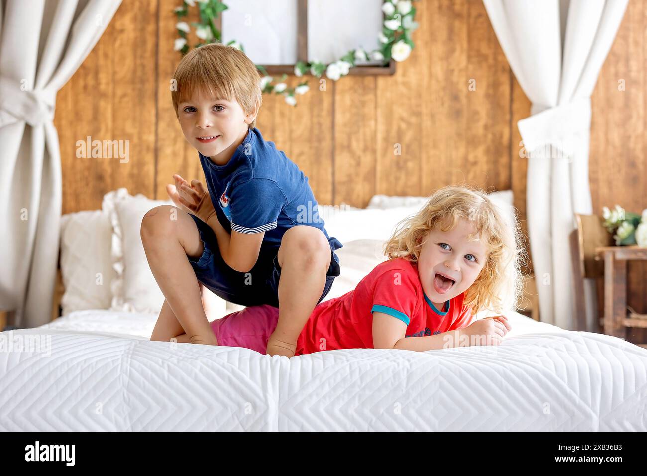 Cute sweet toddler children, tickling feet on the bed, laughing and ...