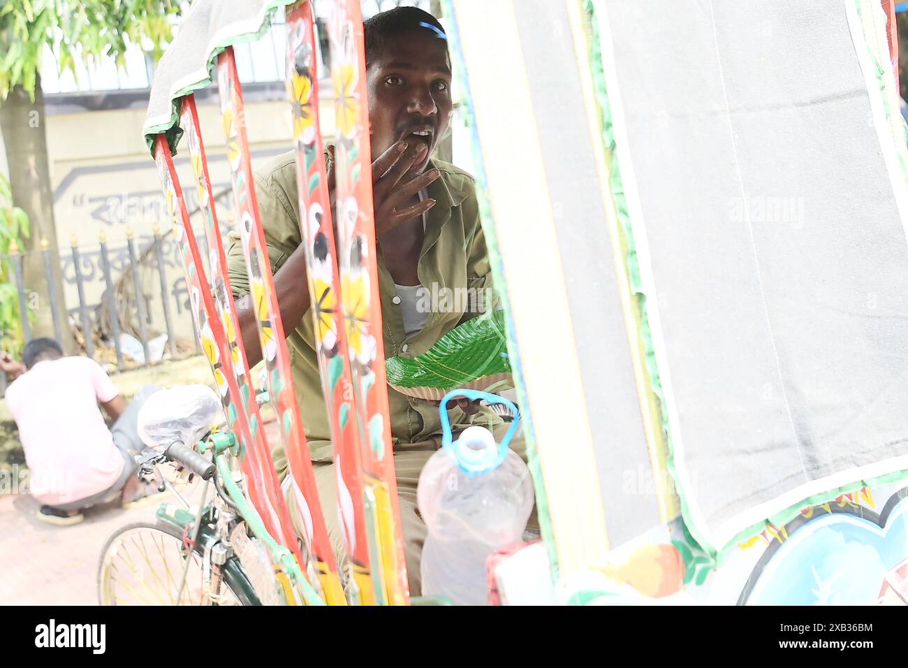 A rickshaw puller eats food distributed by a social worker on World ...