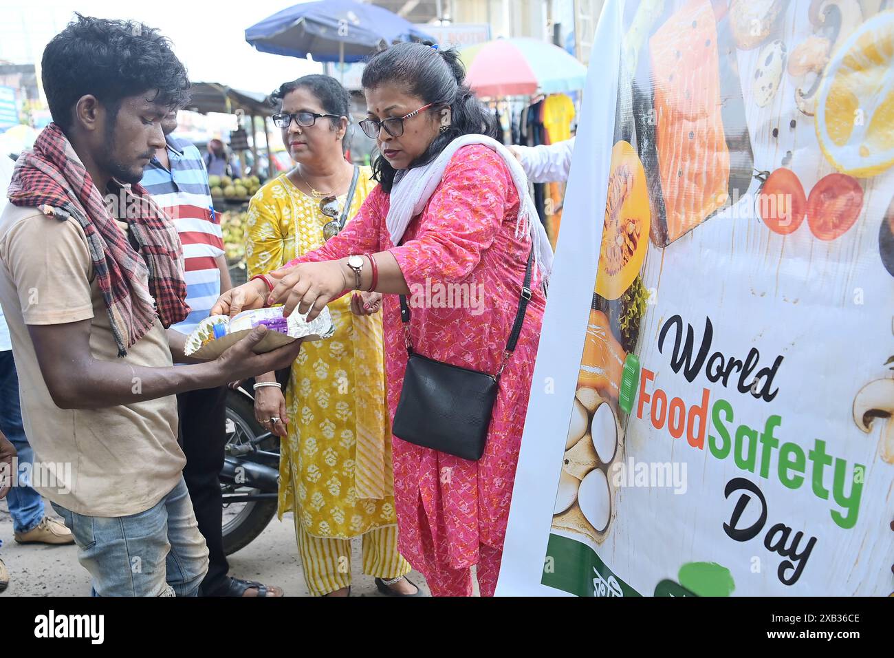 People get food from a social worker on World Food Safety Day ...