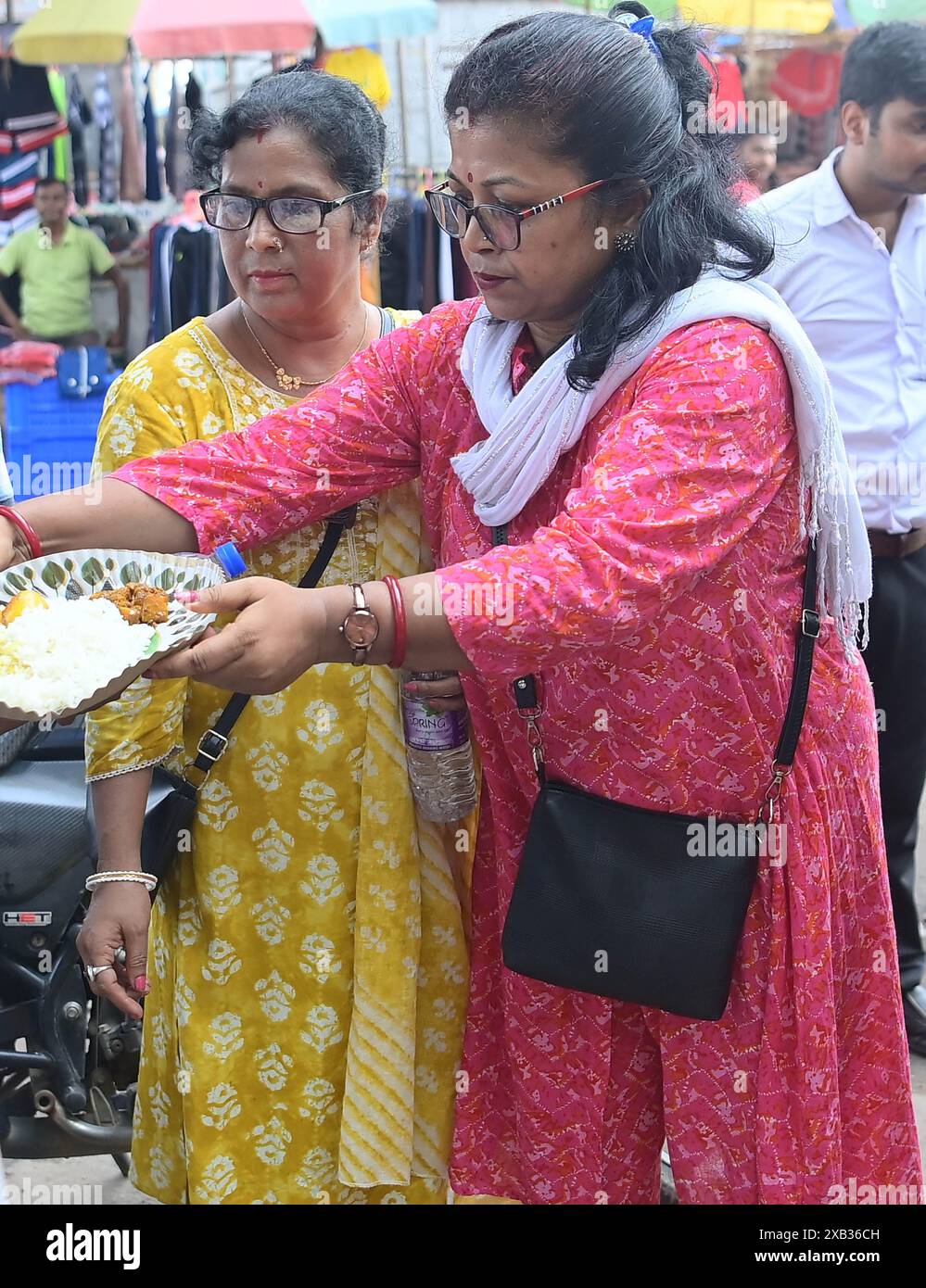 People get food from a social worker on World Food Safety Day ...