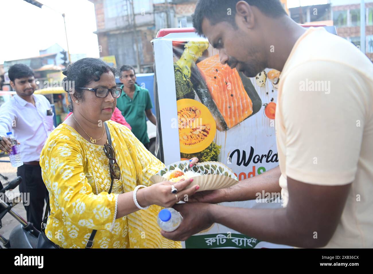People get food from a social worker on World Food Safety Day ...