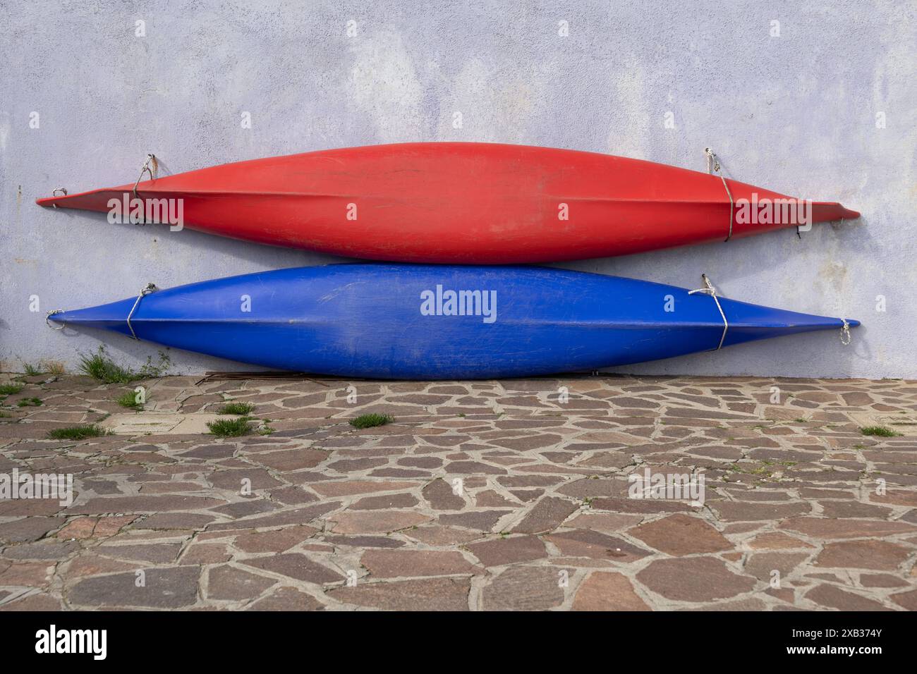 Two kayaks red and blue mounted two a wall Stock Photo - Alamy