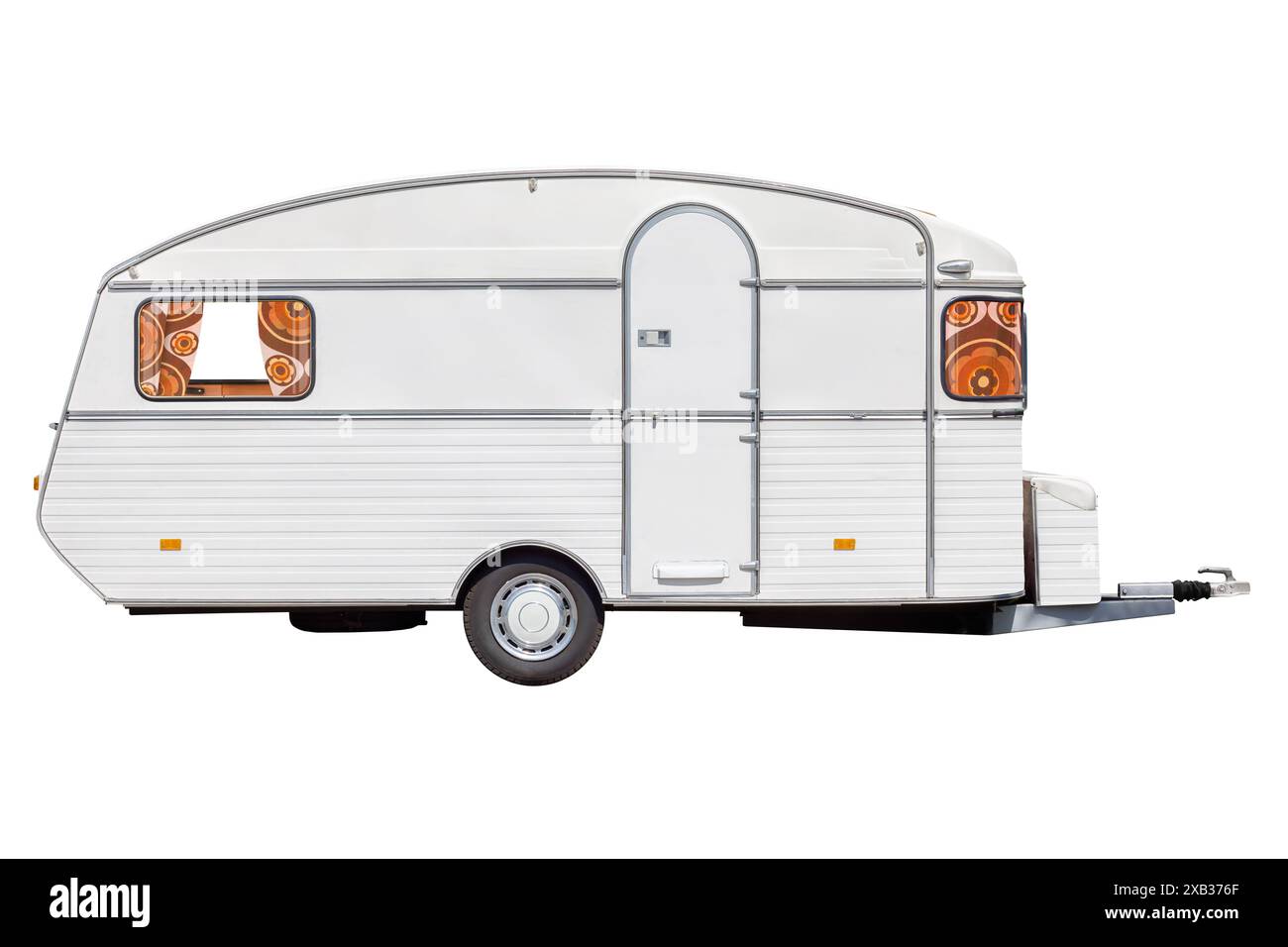 Vintage seventies white caravan with flower curtains isolated on a ...